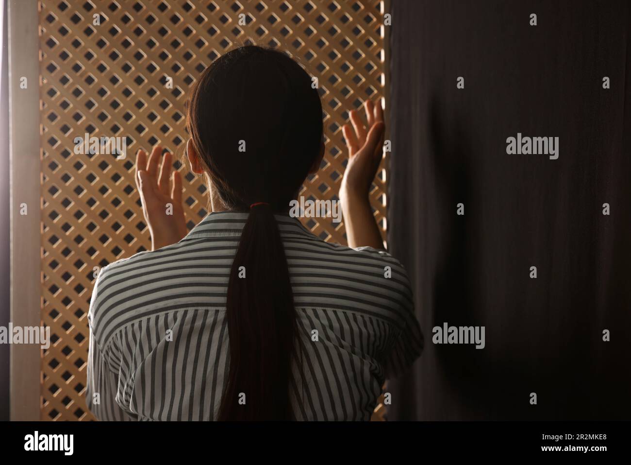 Woman praying to God during confession in booth, back view Stock Photo ...
