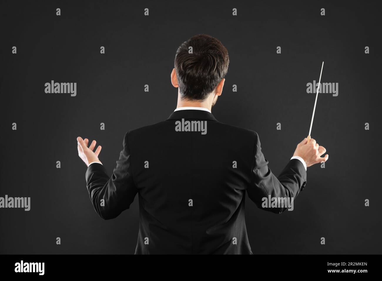 Professional conductor with baton on black background, back view Stock ...