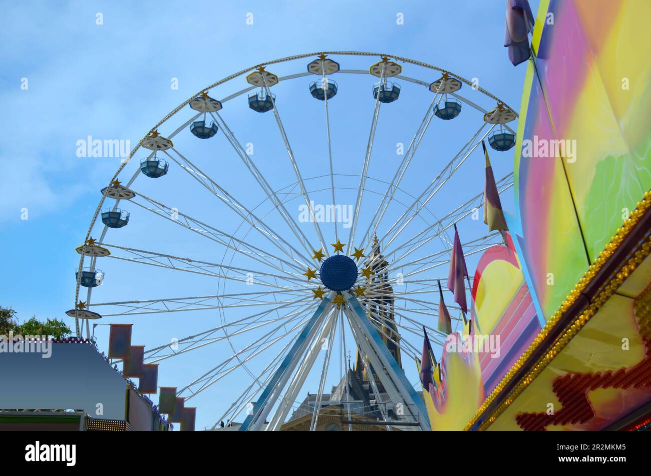 Beautiful large observation wheel in amusement park against blue sky ...