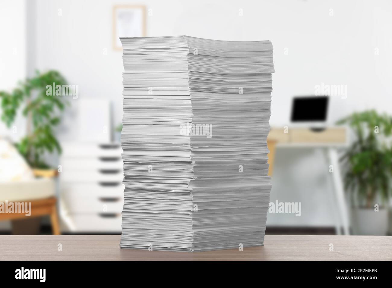 Stacked sheets of paper on wooden table in office Stock Photo - Alamy