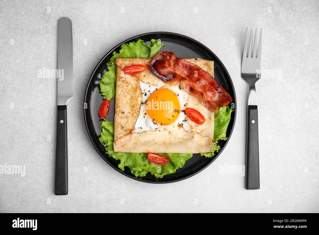 Delicious crepe with egg on light gray table, top view. Breton galette ...