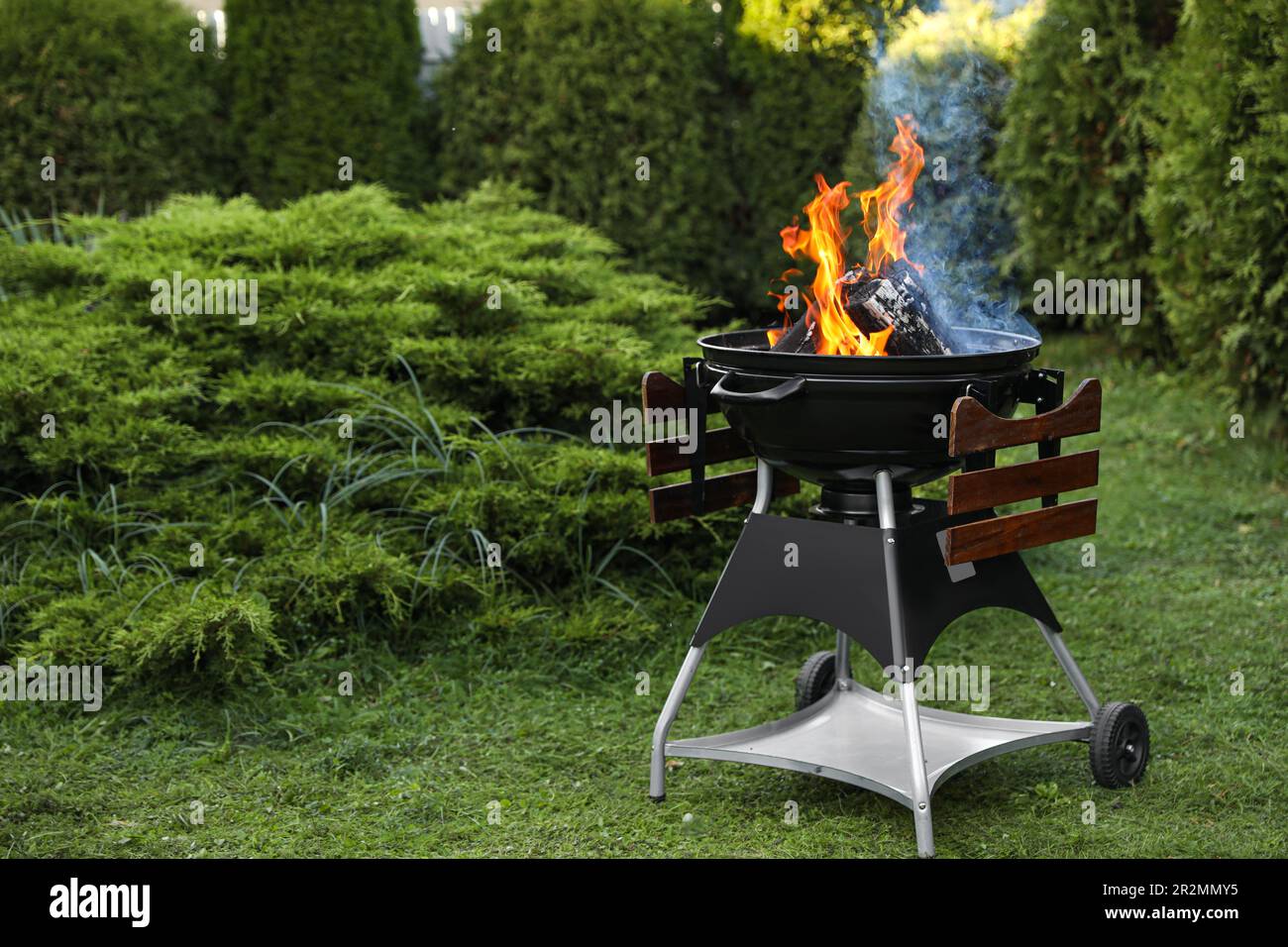 Portable barbecue grill with fire flames outdoors. Space for text Stock ...