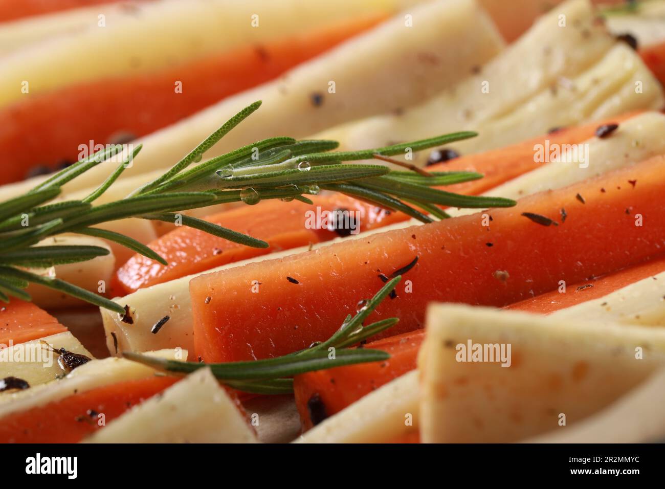 Slices of parsnip and carrot with rosemary, closeup Stock Photo - Alamy