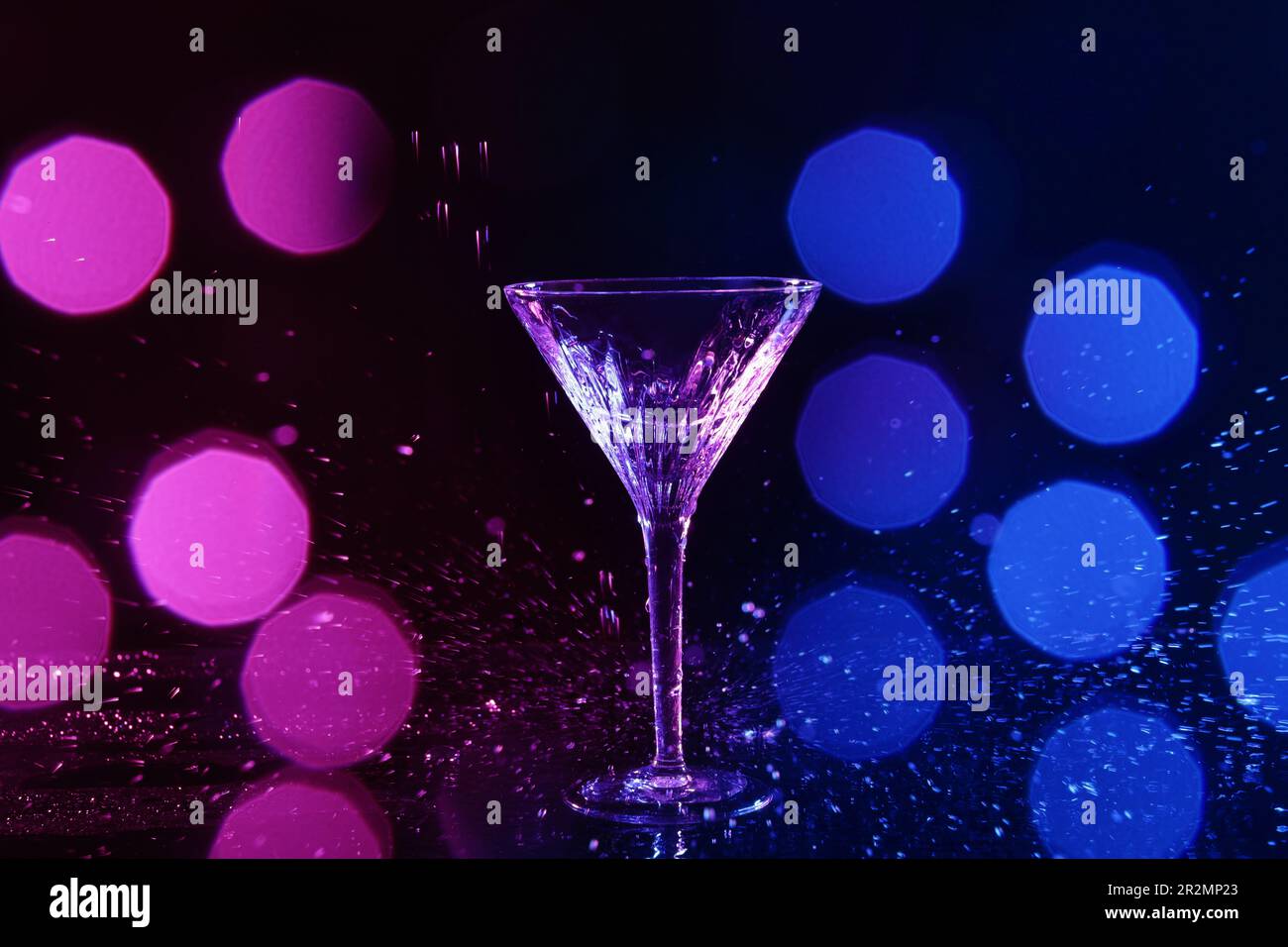 Martini glass and splashes in neon lights on dark background, bokeh effect Stock Photo - Alamy