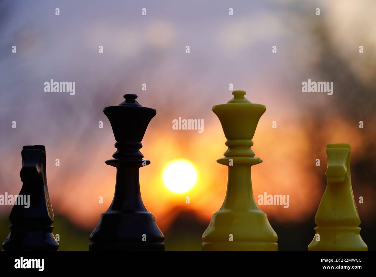 chess pieces on sunset background and golden hour Stock Photo - Alamy