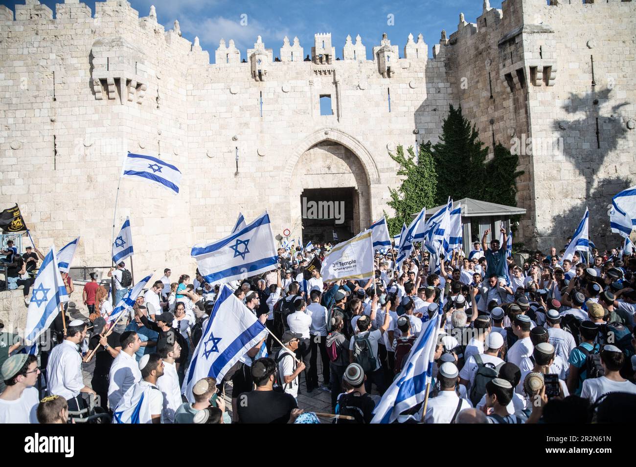 Israeli religious youth wave Israeli flags as they walk pass the closed ...