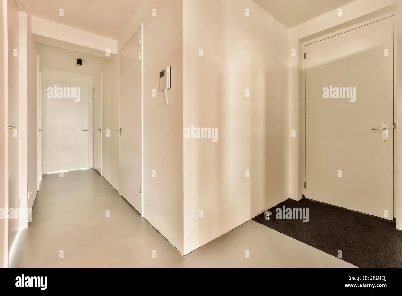 an empty room with white walls and black flooring on the right side of ...
