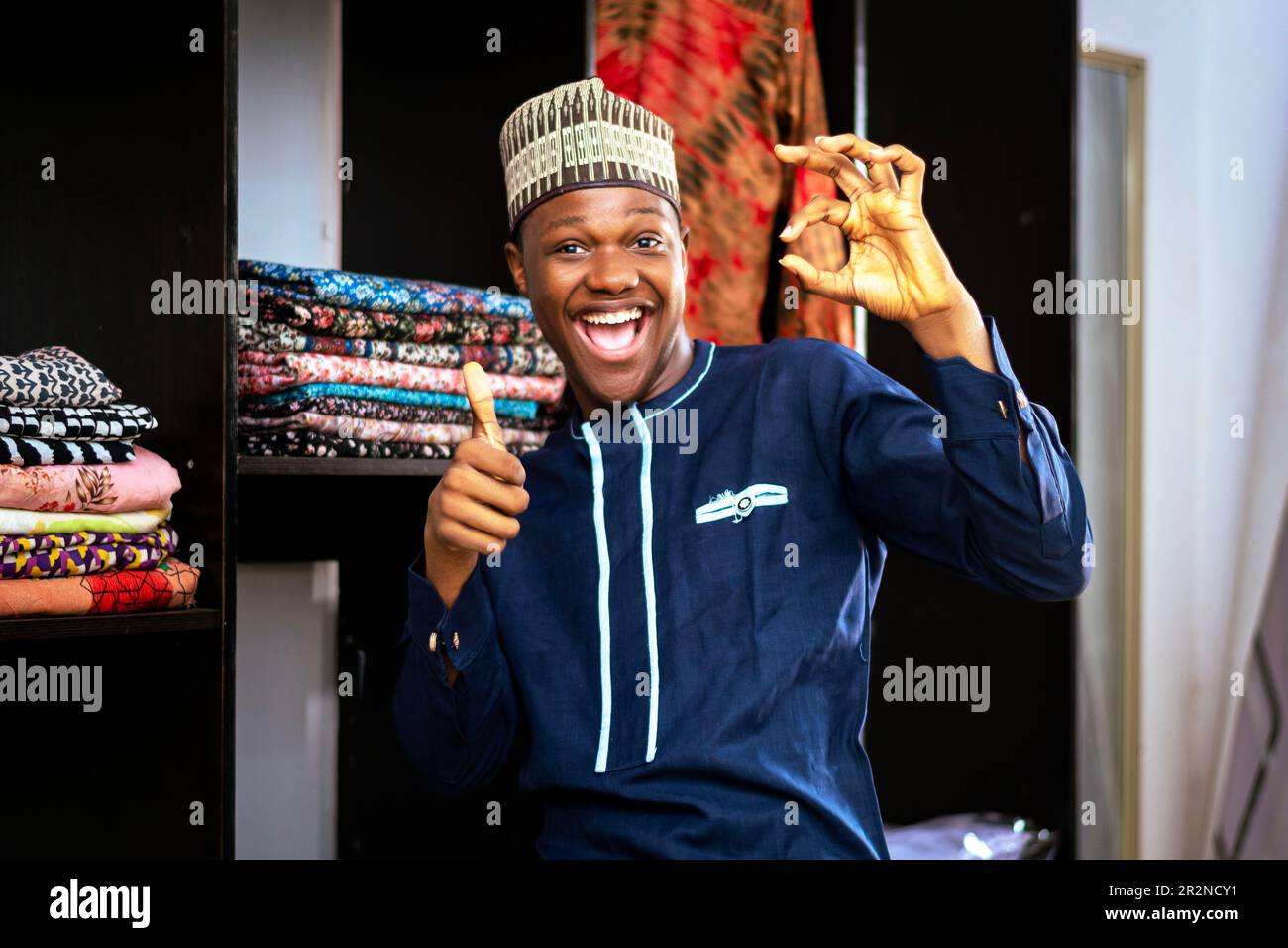 Photo of an African man browsing through a rack of clothes in a store ...