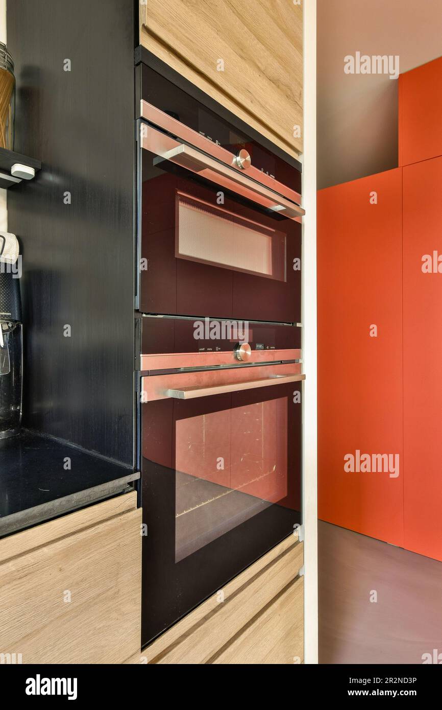 a kitchen with an oven and red cabinetd cupboards in the wall behind it ...