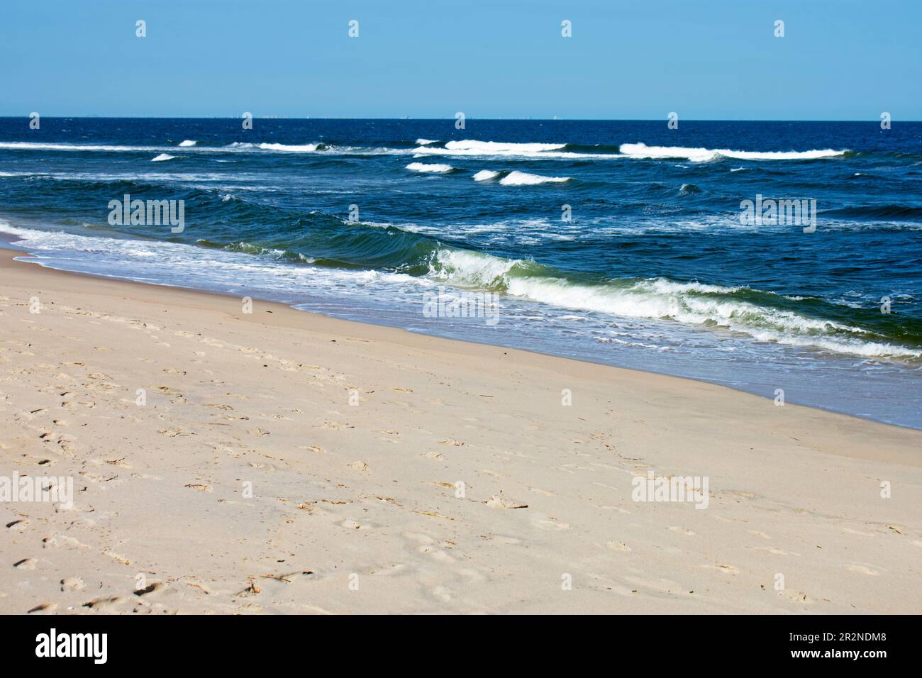 Light winds off the ocean cause waves to crash into the shore at a ...