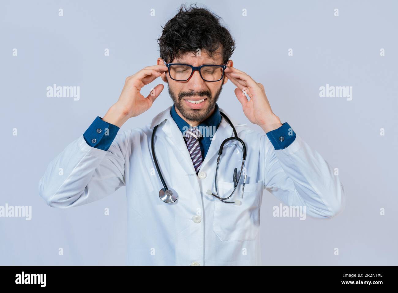 Young Doctor suffering with headache isolated. Doctor with migraine ...