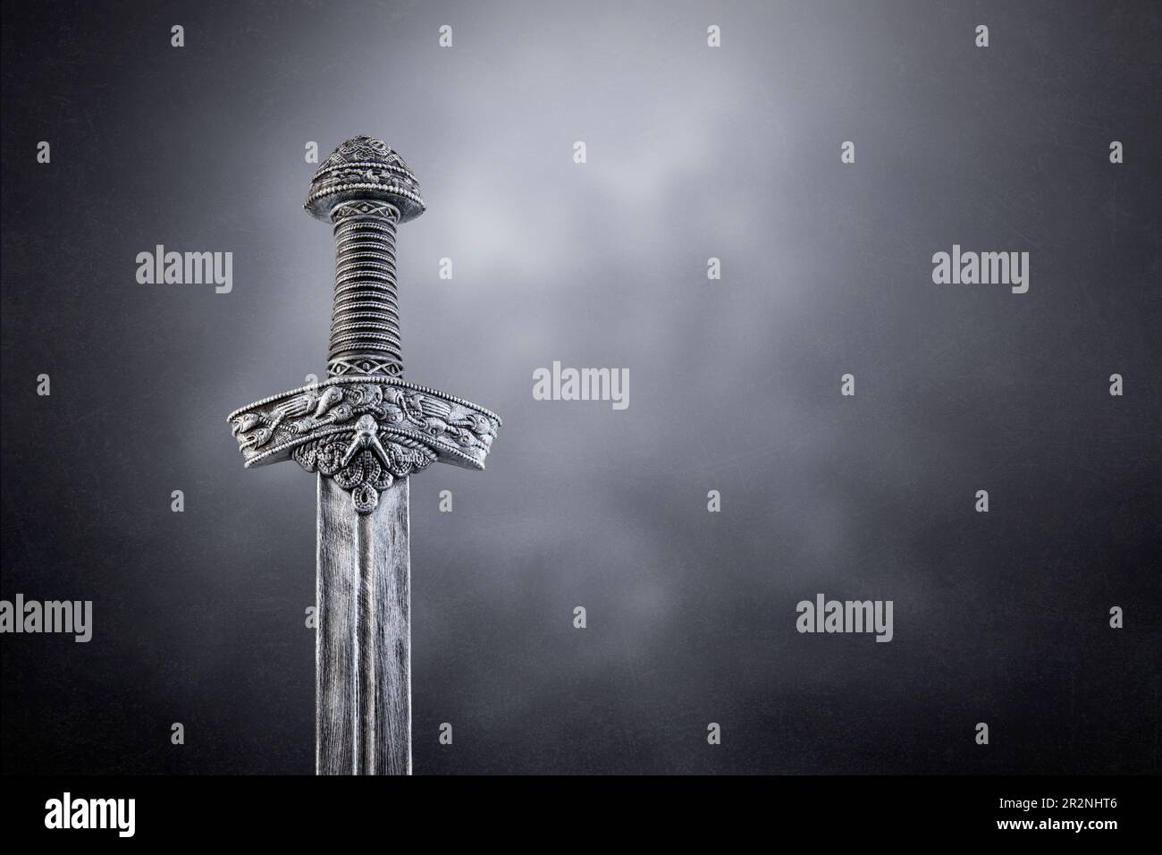 Medieval sword over dark misty background Stock Photo - Alamy