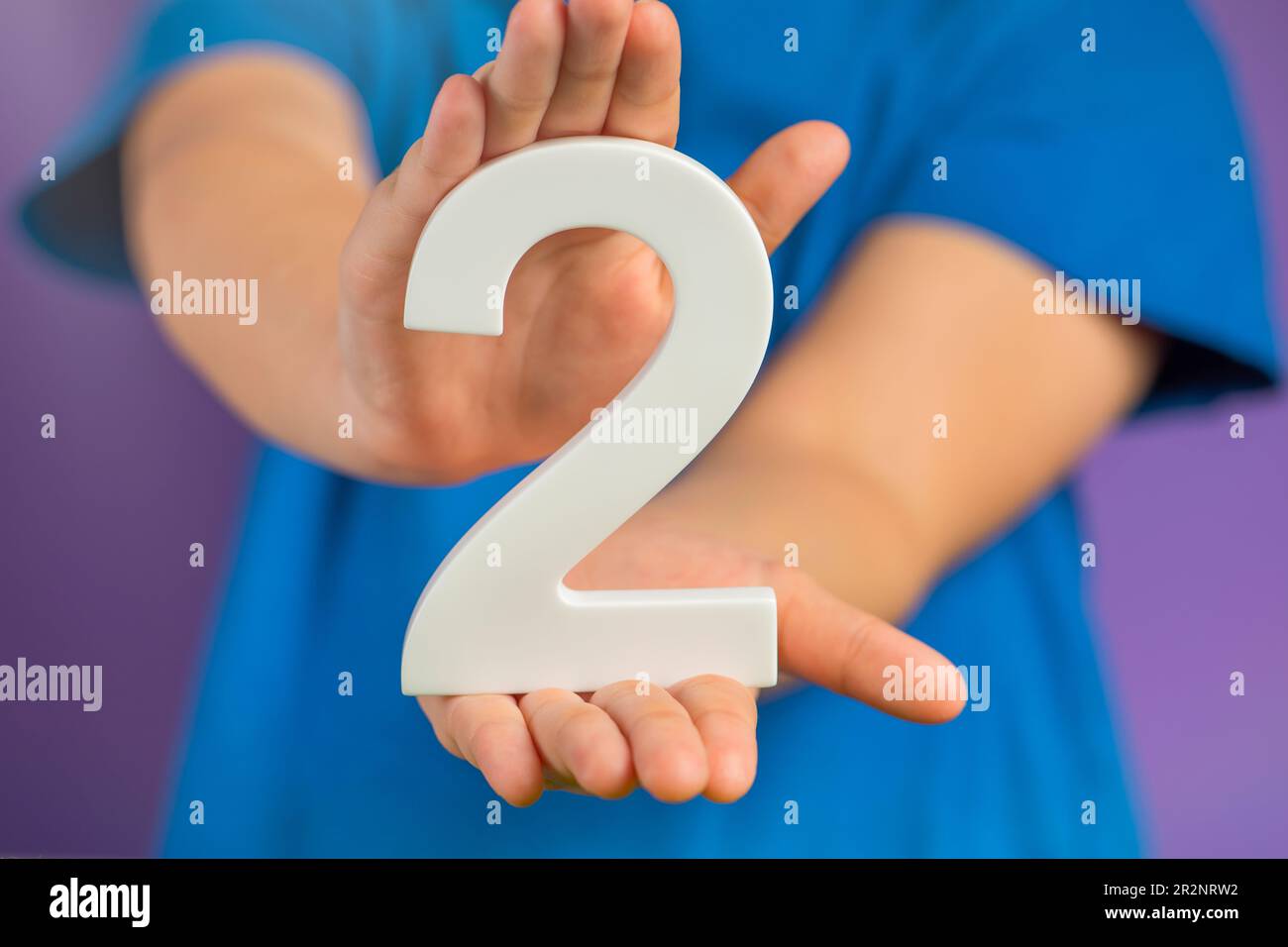 White number 2 in hand. The hand holding the number 2 symbolizes choice ...