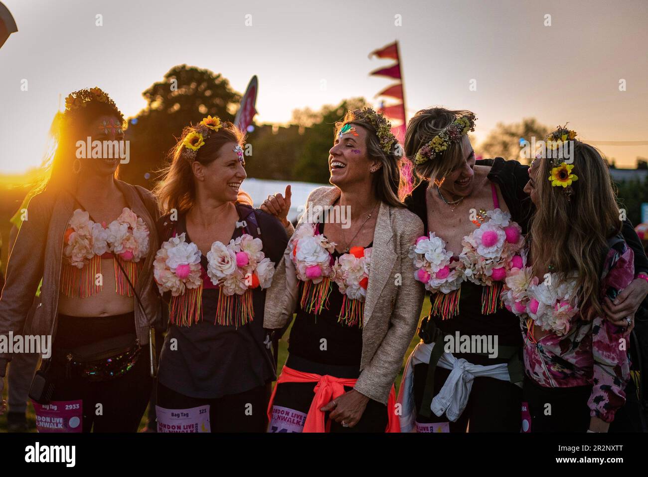 A group of walkers gather during sunset at the start of Moonwalk London ...