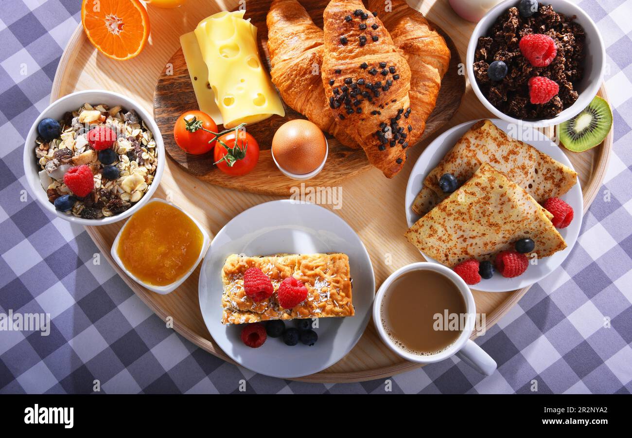 Breakfast served with coffee, orange juice, croissants, pancake, egg ...