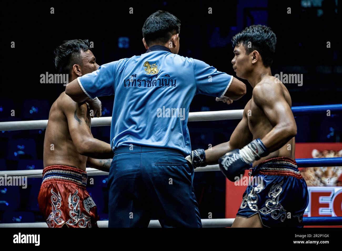 A referee tries to separate Muay Thai boxers during a fight, at ...