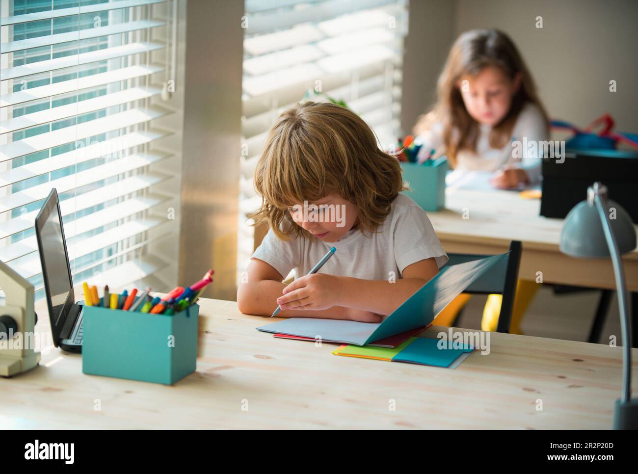 Kid studying at school. Schoolchild doing homework at classroom ...