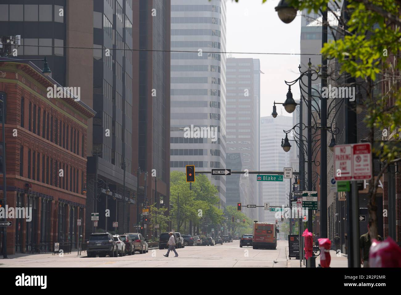 As a smoky haze shrouds the high-rise buildings, pedestrians walk ...