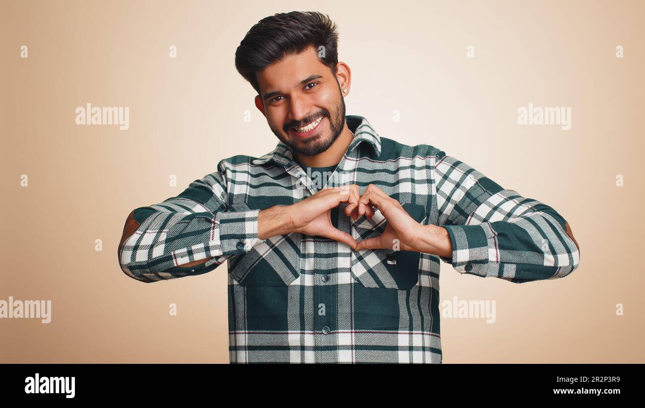 Man in love. Smiling bearded indian man 25 years old makes heart ...