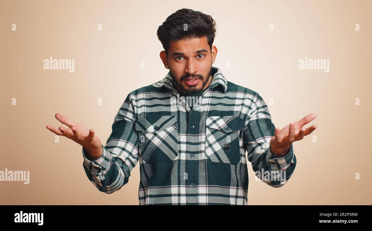 What Why. Sincere irritated indian man raising hands in indignant ...