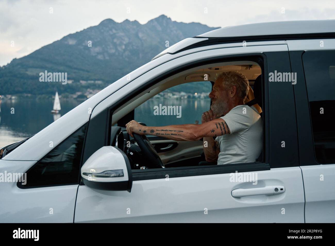 Happy older man driving camper van on mountains adventure Stock Photo ...