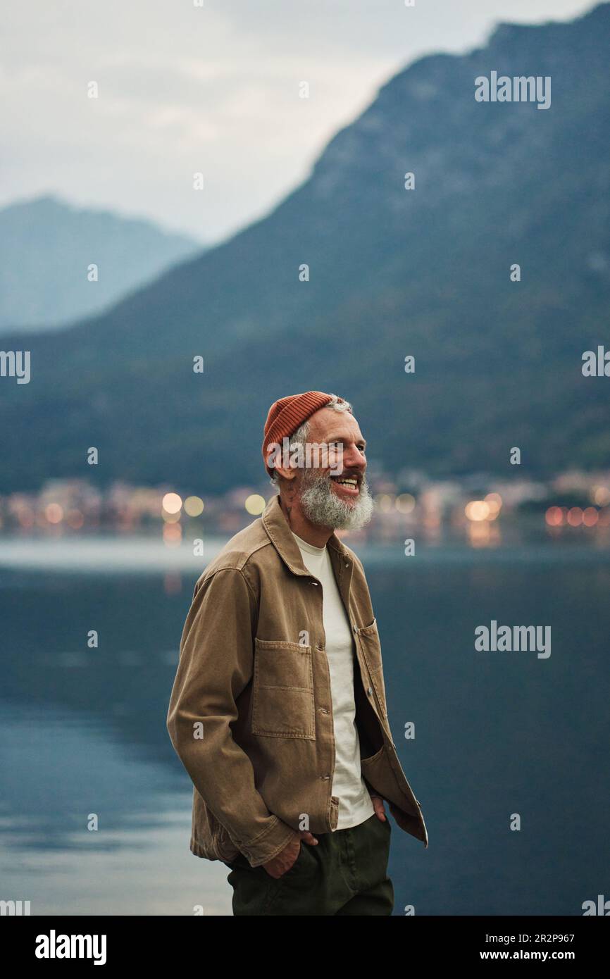 Happy older man standing in nature park enjoying natural landscape ...