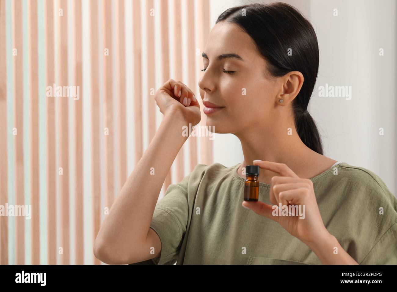 Woman smelling perfume on her wrist hi-res stock photography and images ...
