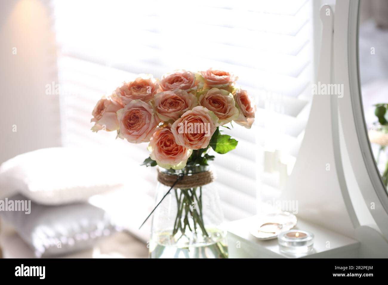 Glass vase with beautiful flowers on dressing table in modern room ...