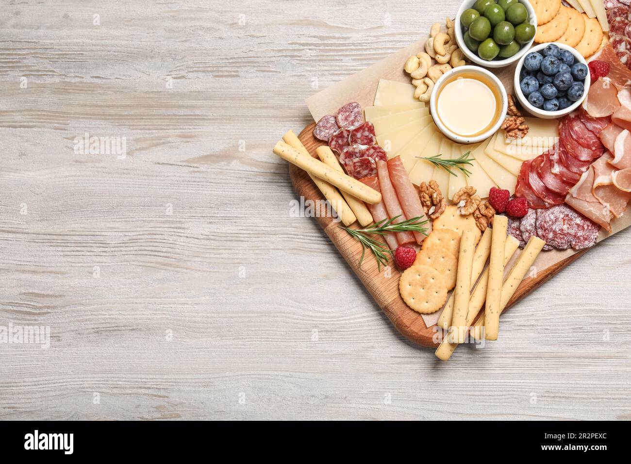 Tasty parmesan cheese and other different appetizers on white wooden ...