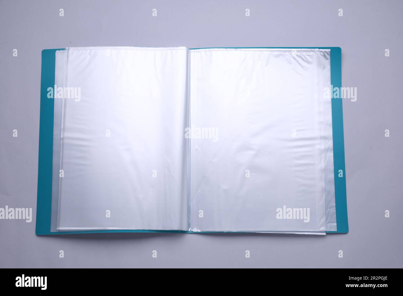File folder with punched pockets and paper sheets on light grey ...