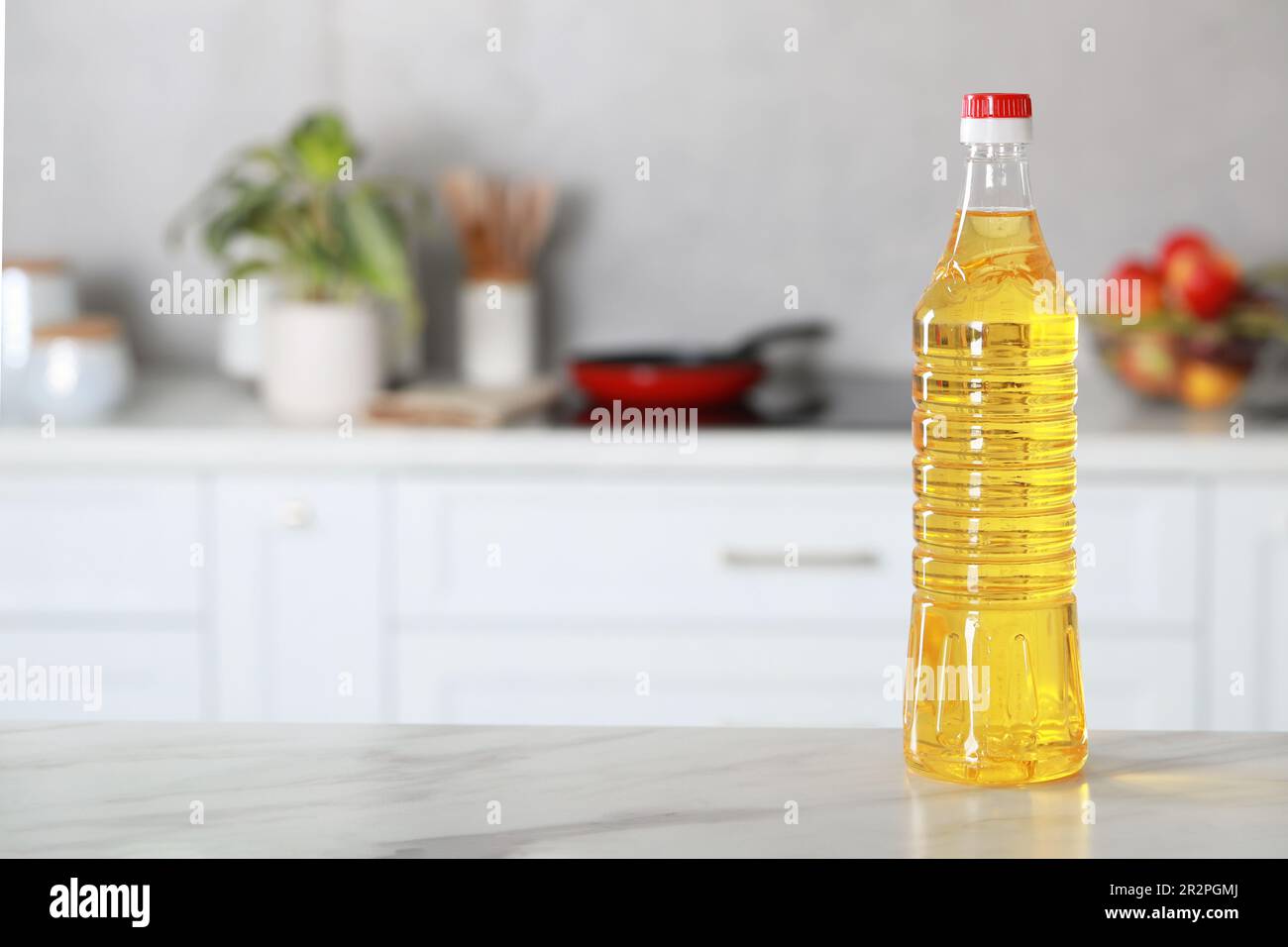 Bottle of cooking oil on white marble table in kitchen. Space for text ...