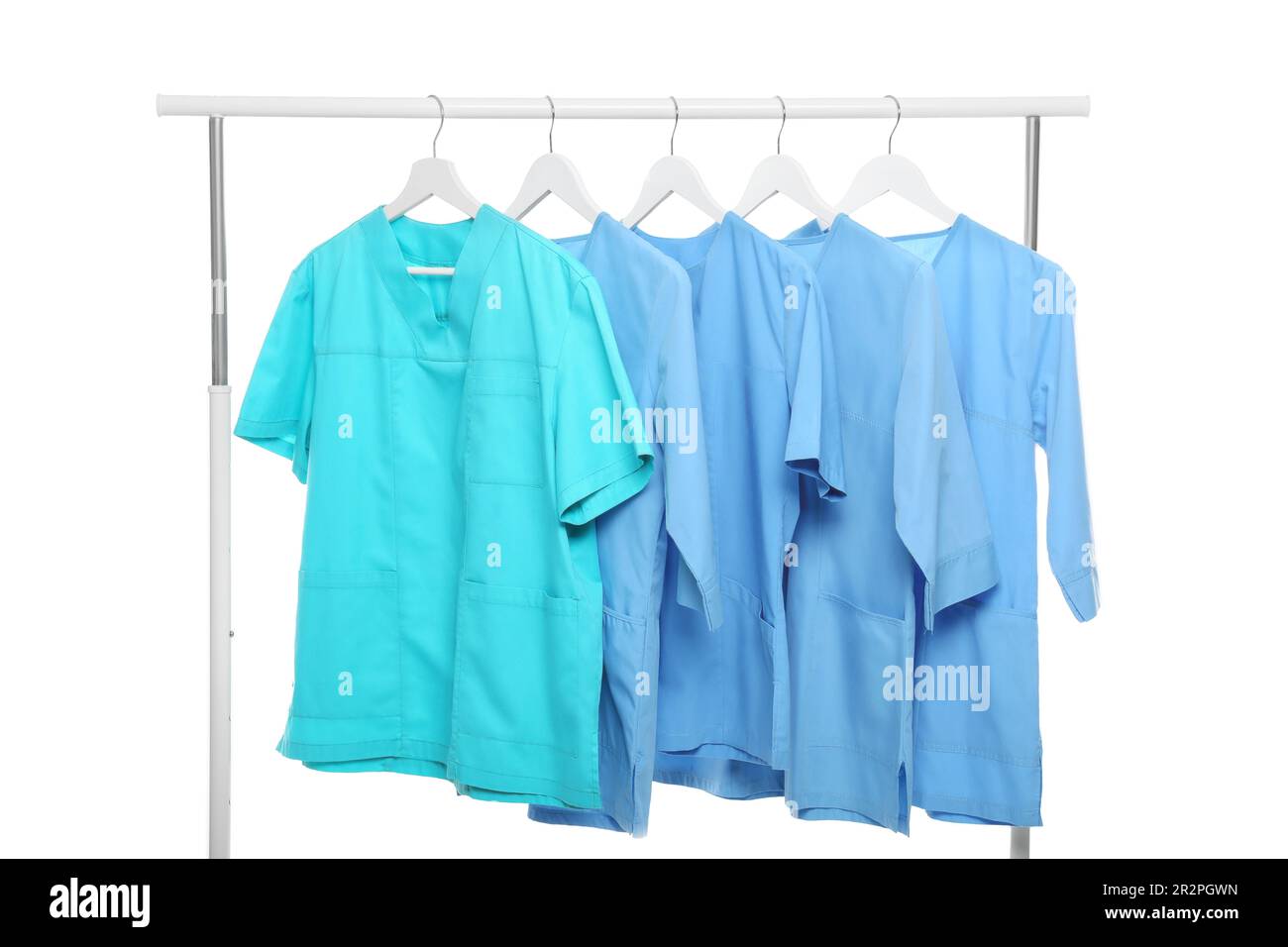 Turquoise and light blue medical uniforms on rack against white ...