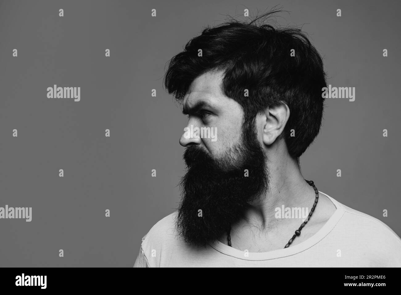 Half-turned side profile portrait of serious man has beard and mustache, looks seriously ...