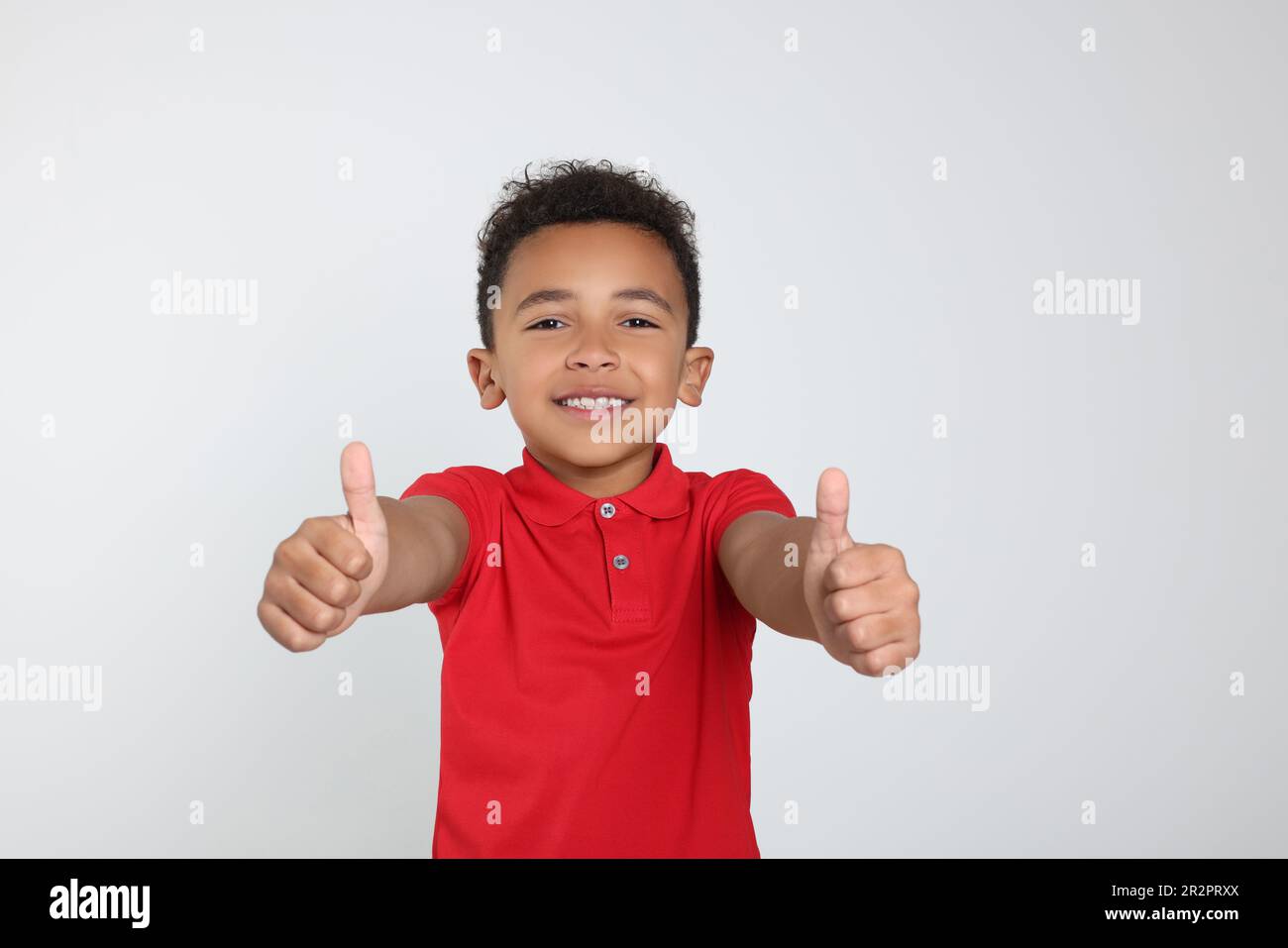 African-American boy showing thumbs up on light grey background Stock ...