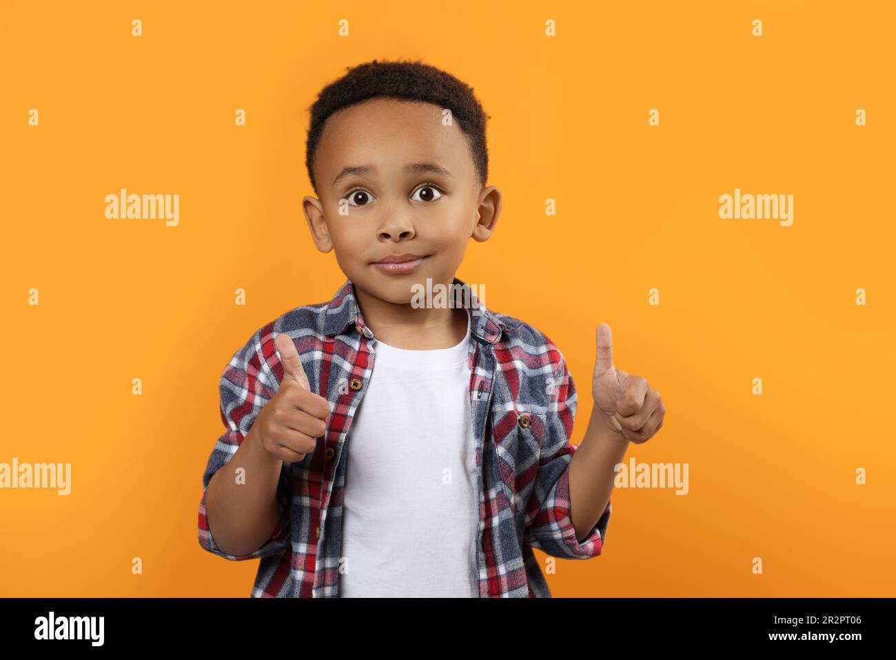 African-American boy showing thumbs up on orange background Stock Photo ...