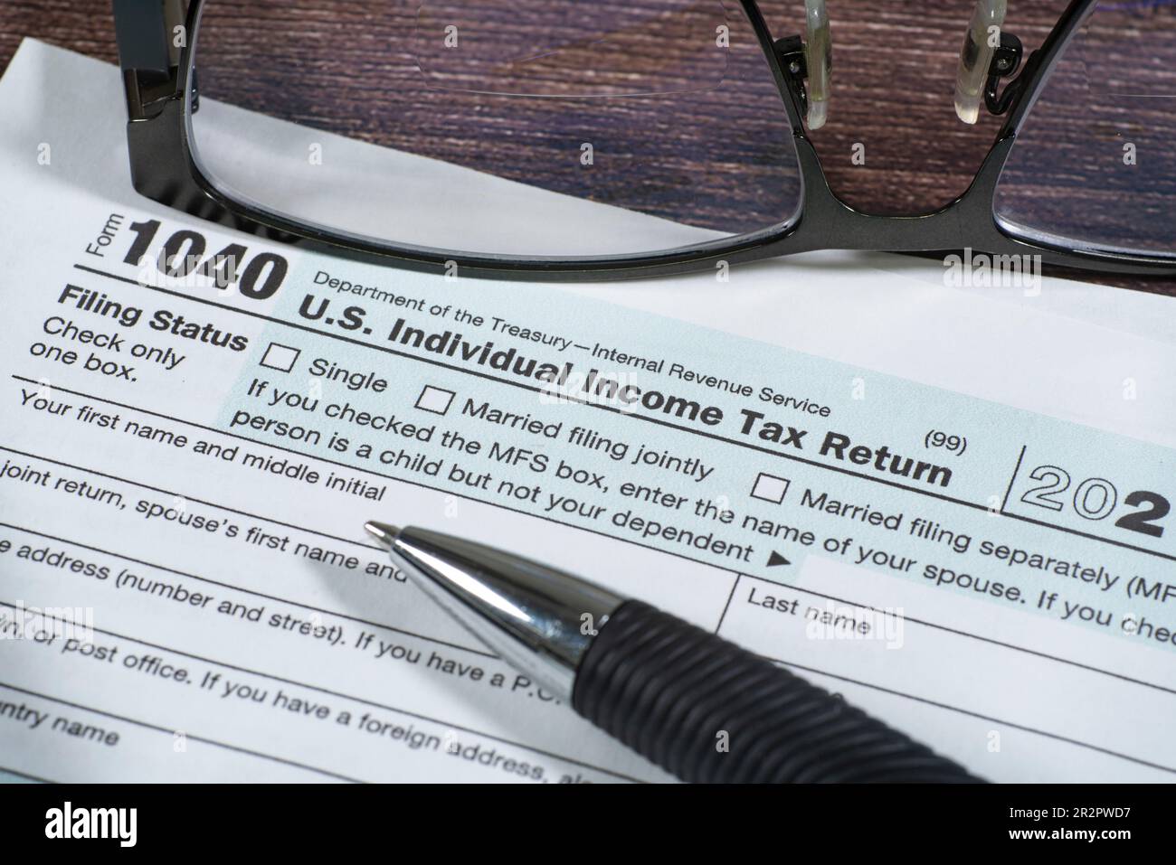 Close up of upper left corner of IRS form 1040 with eyeglasses and pen ...