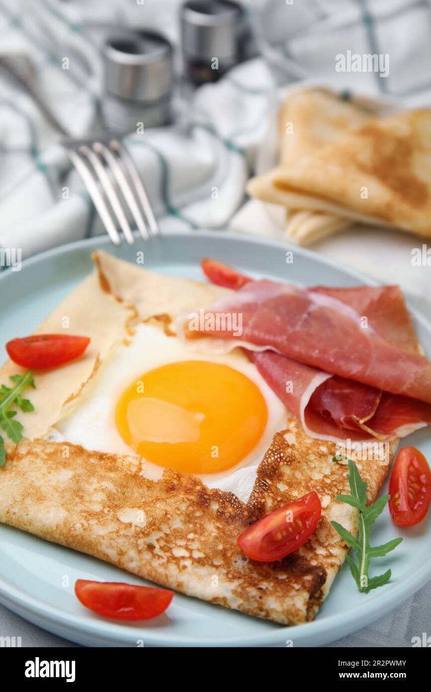 Delicious crepe with egg served on table, closeup. Breton galette Stock ...