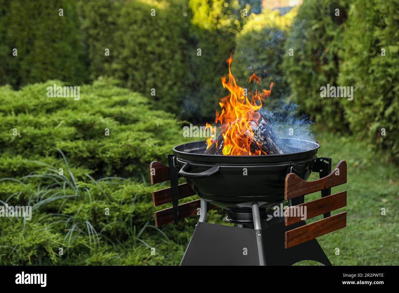 Portable barbecue grill with fire flames outdoors. Space for text Stock ...
