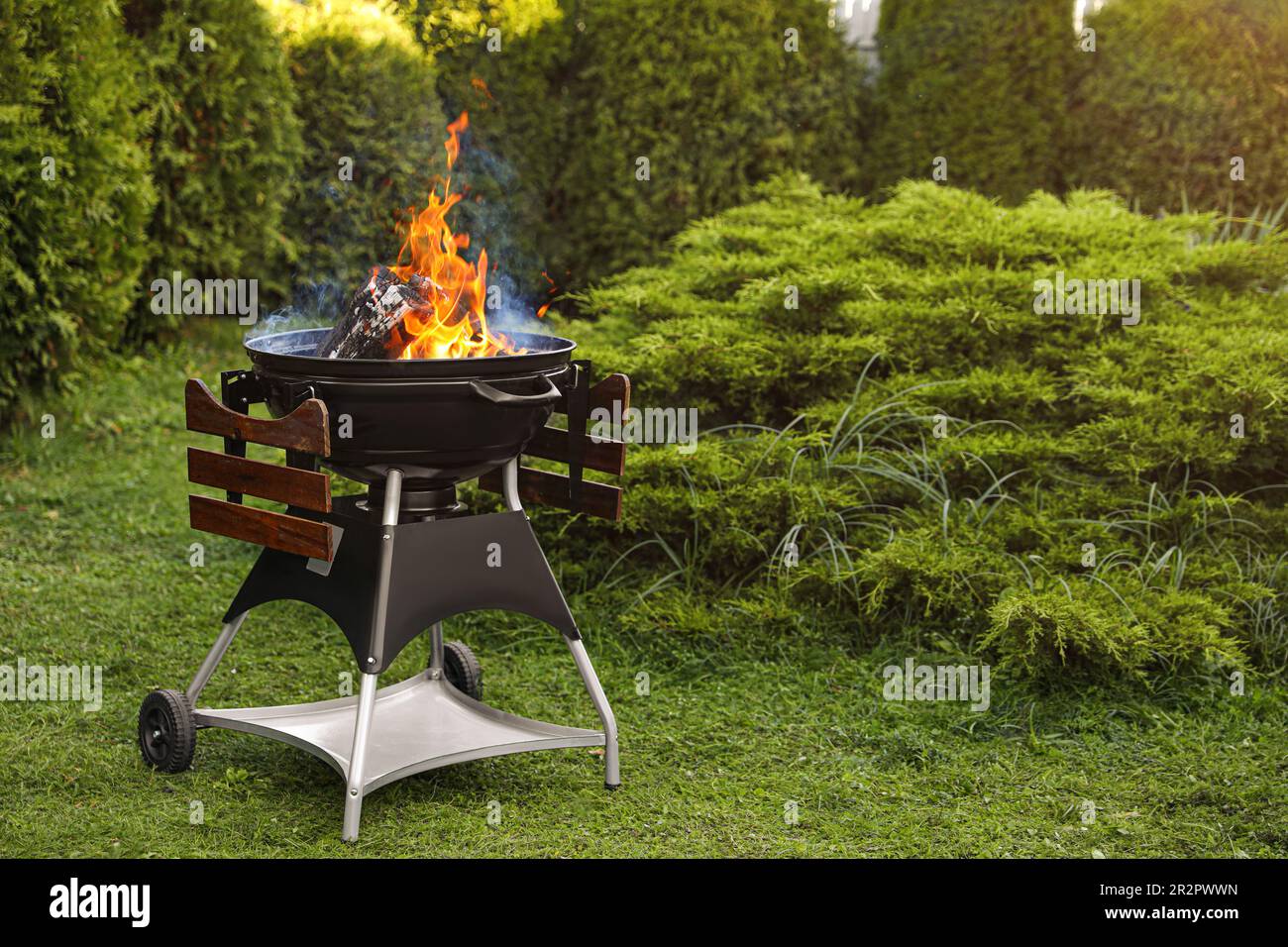 Portable barbecue grill with fire flames outdoors. Space for text Stock ...
