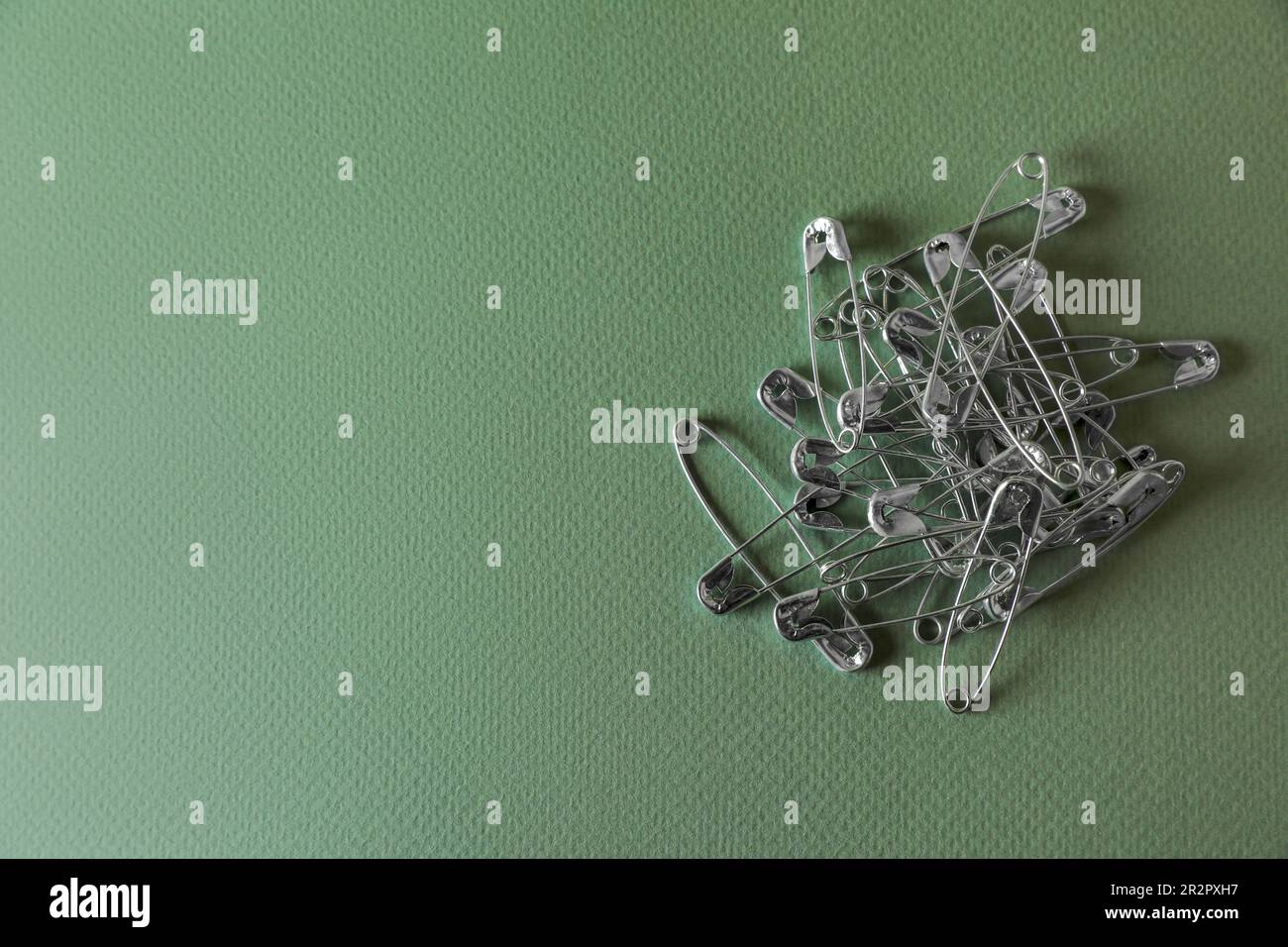 Pile of safety pins on green background, flat lay. Space for text Stock ...
