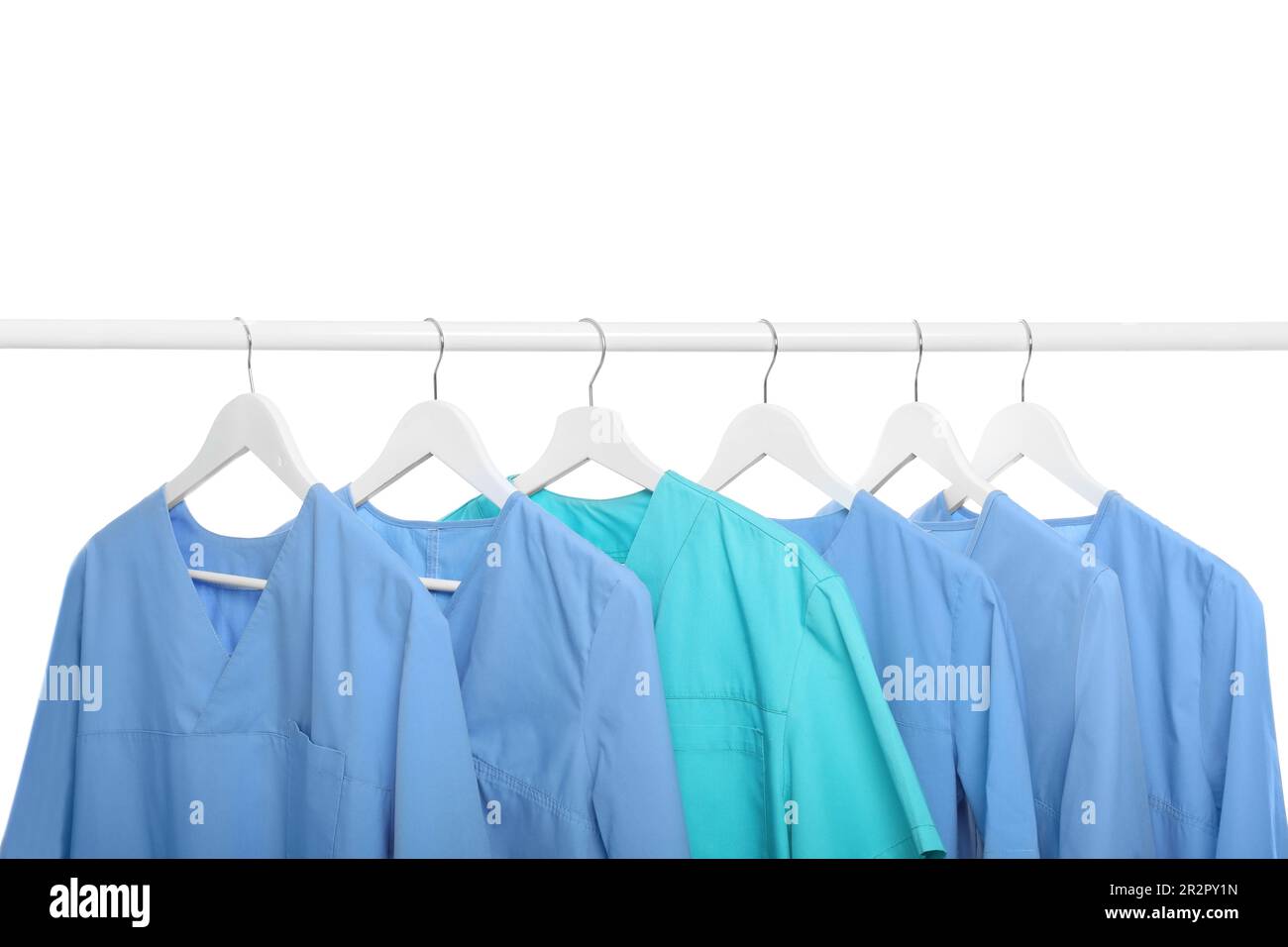 Light blue and turquoise medical uniforms on rack against white ...