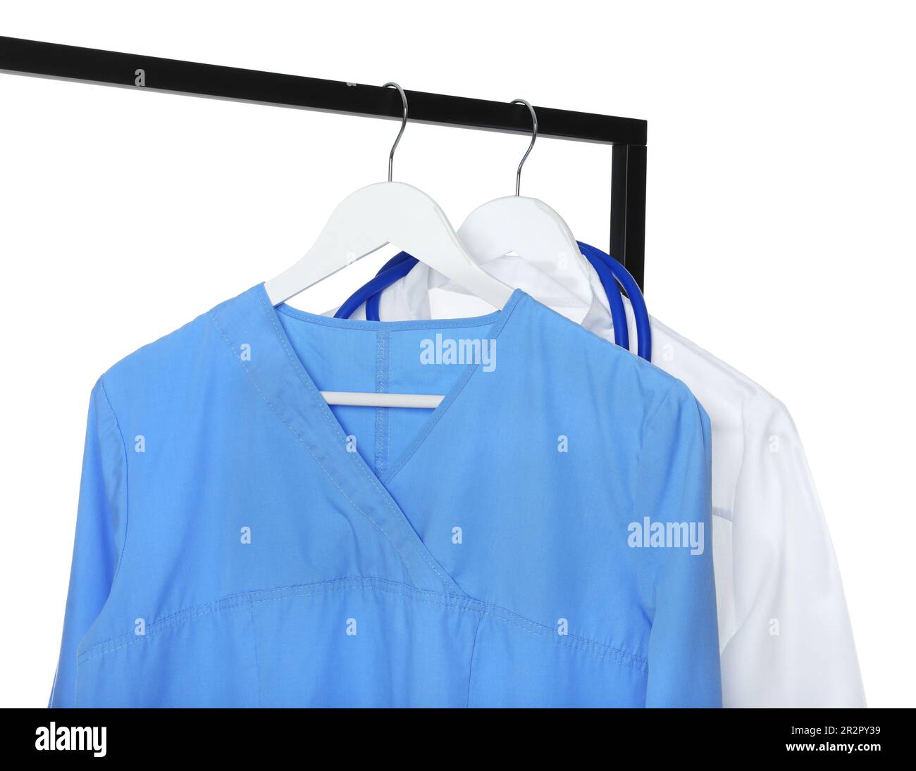 Light blue medical uniform and doctor's gown on rack against white ...