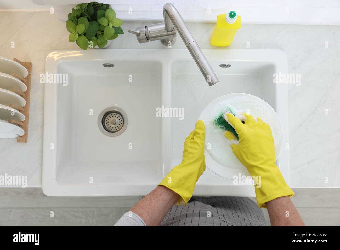 Man washing plate in kitchen sink, top view Stock Photo - Alamy
