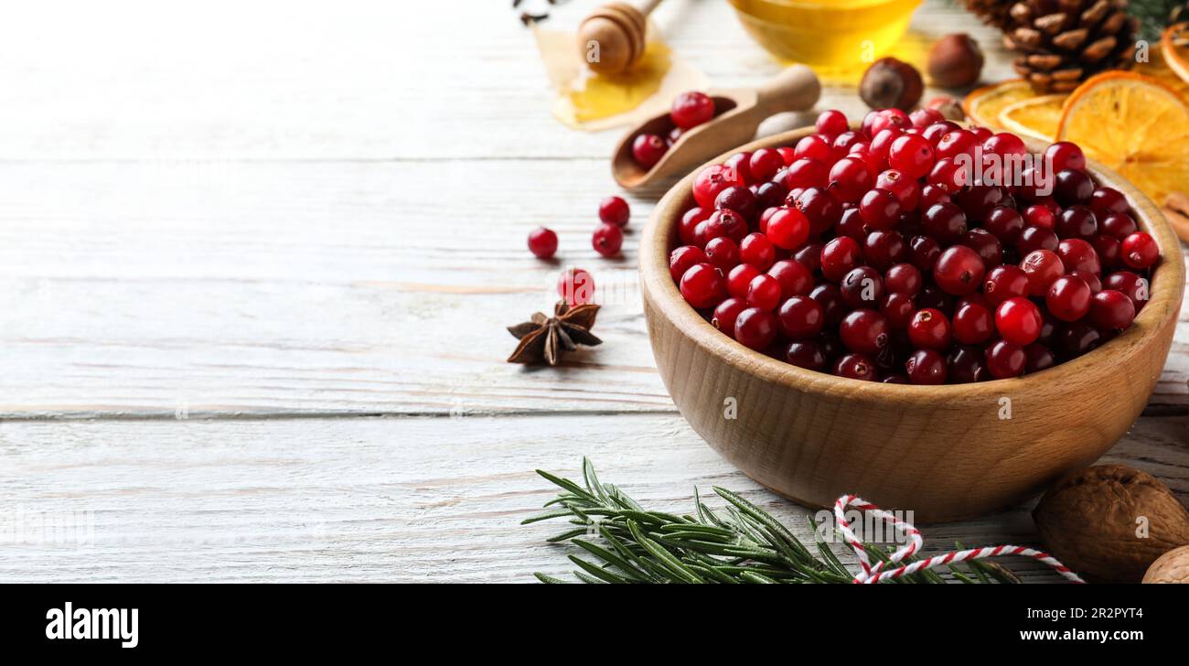 Fresh ripe cranberries, spices and products on white wooden table ...