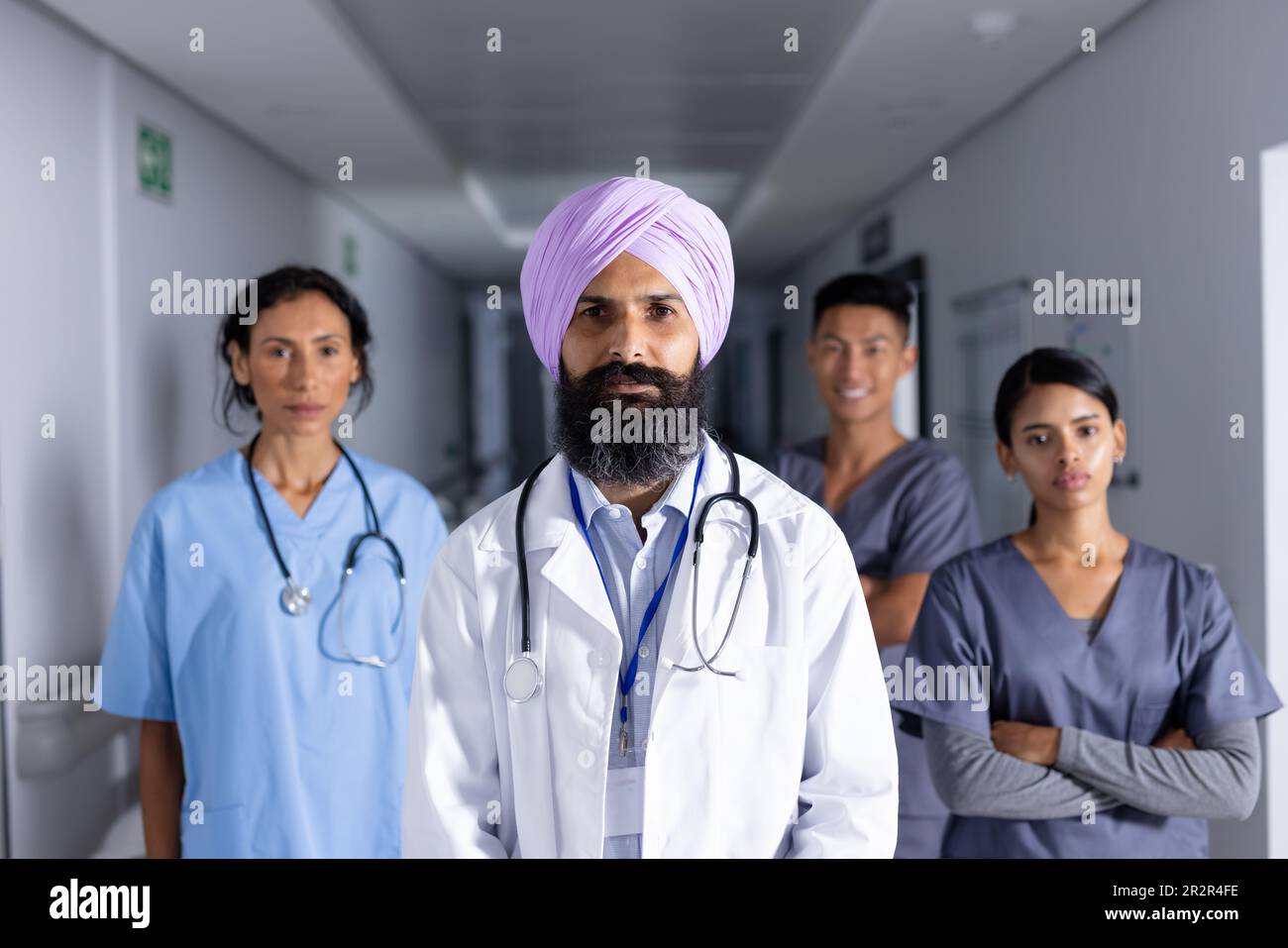 Group portrait of diverse male and female doctors standing in corridor ...