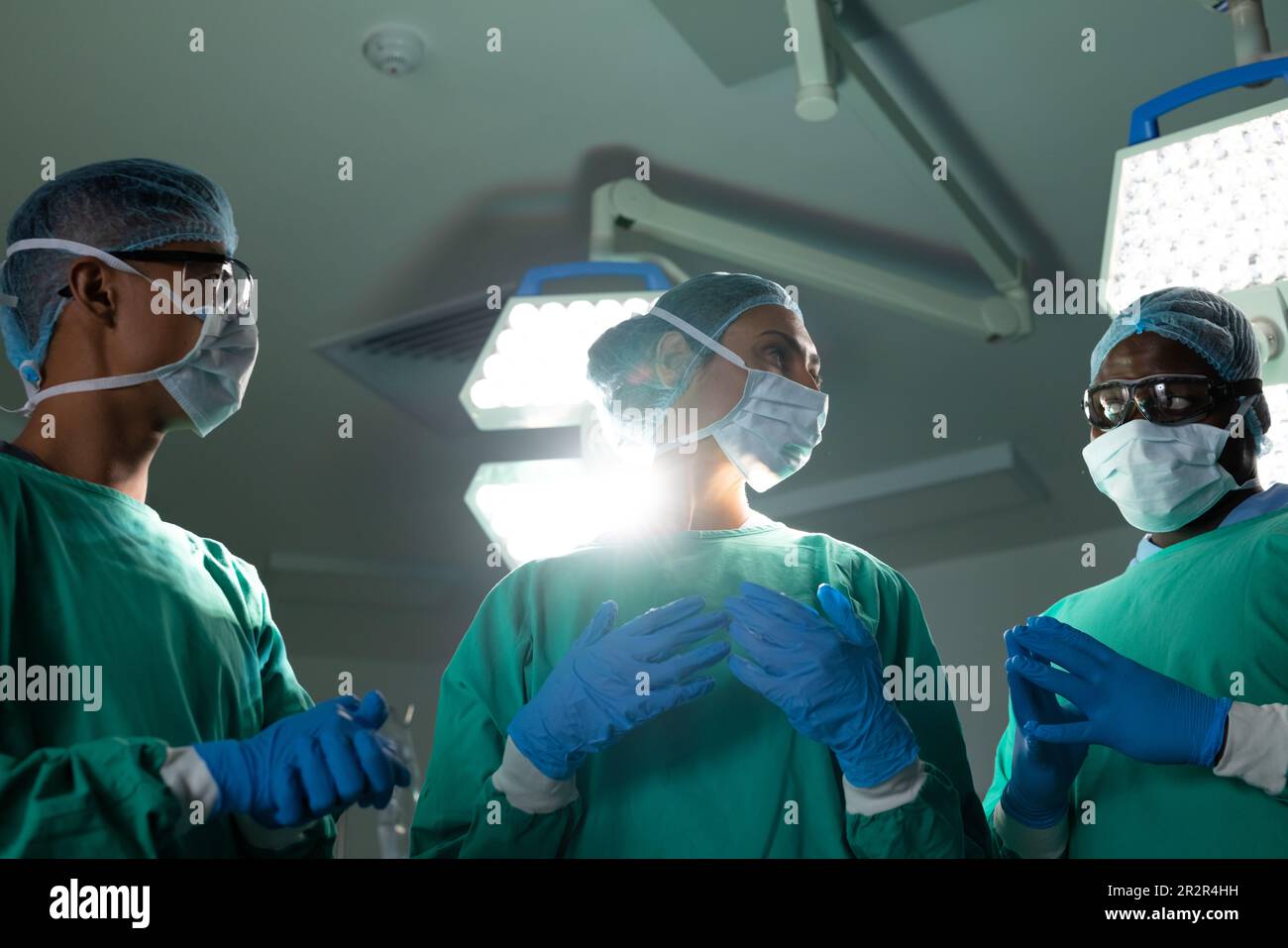 Diverse male and female surgeons ready for surgery in discussion in ...
