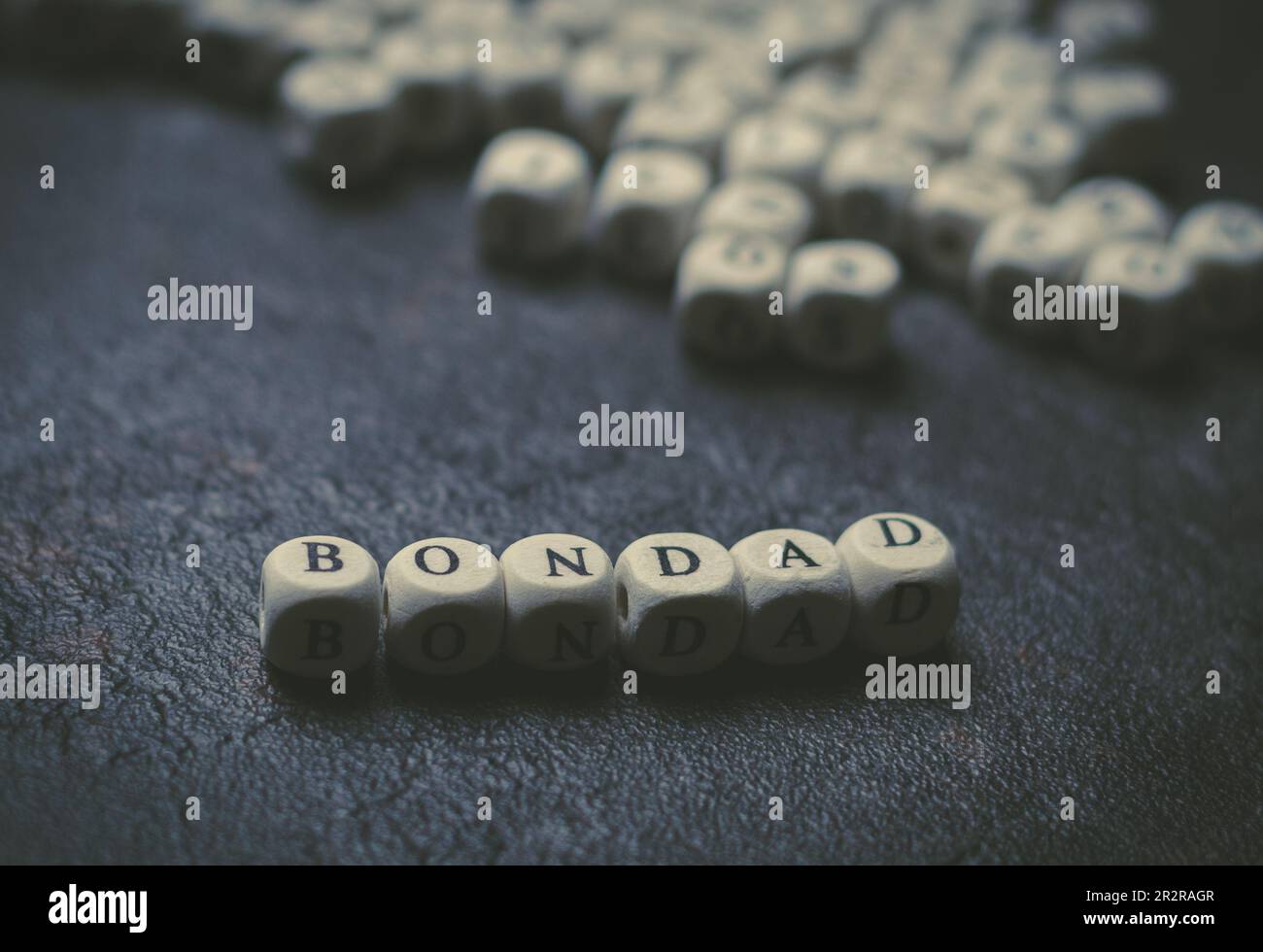 Cubos de madera con letras en fondo negro formando la palabra bondad ...