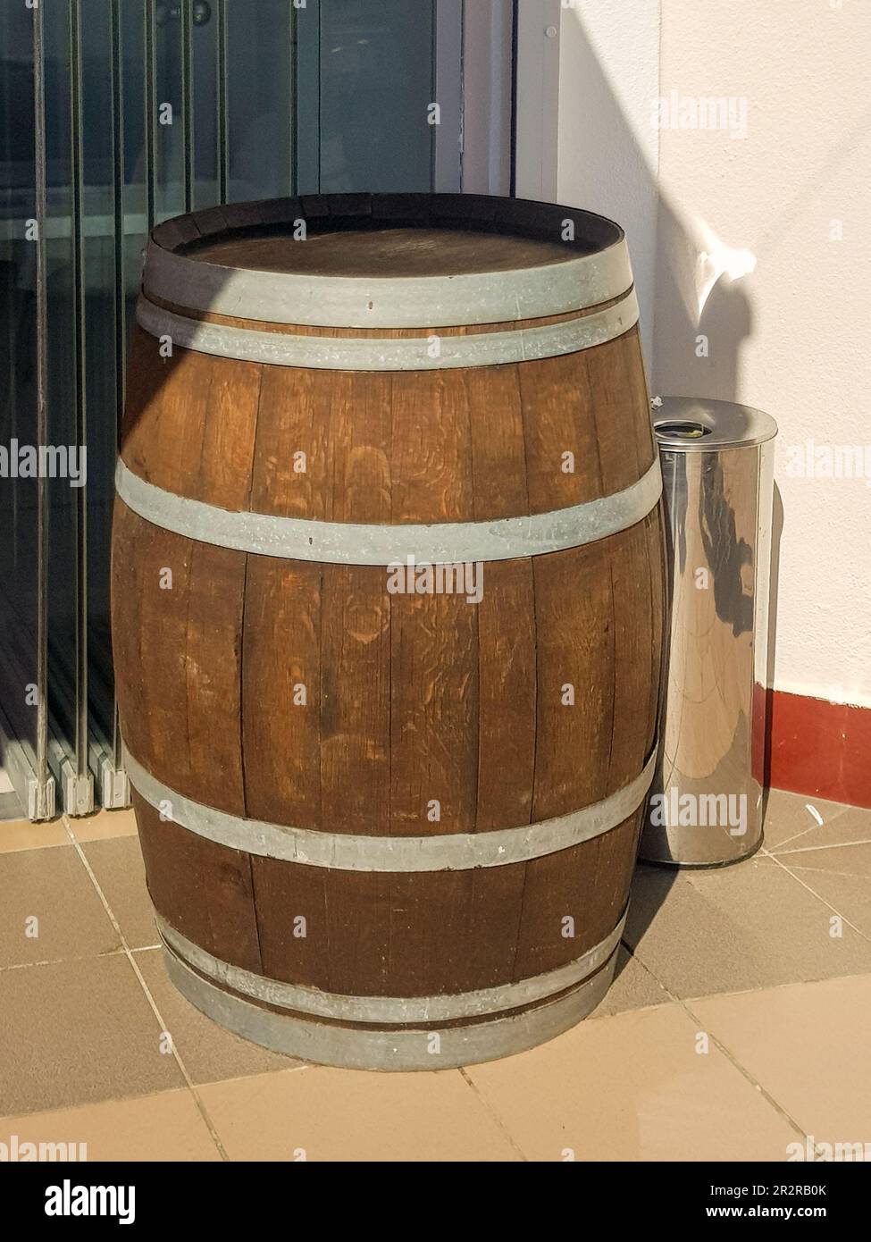 An old oak barrel stands at the entrance to a beer restaurant, shop, as ...