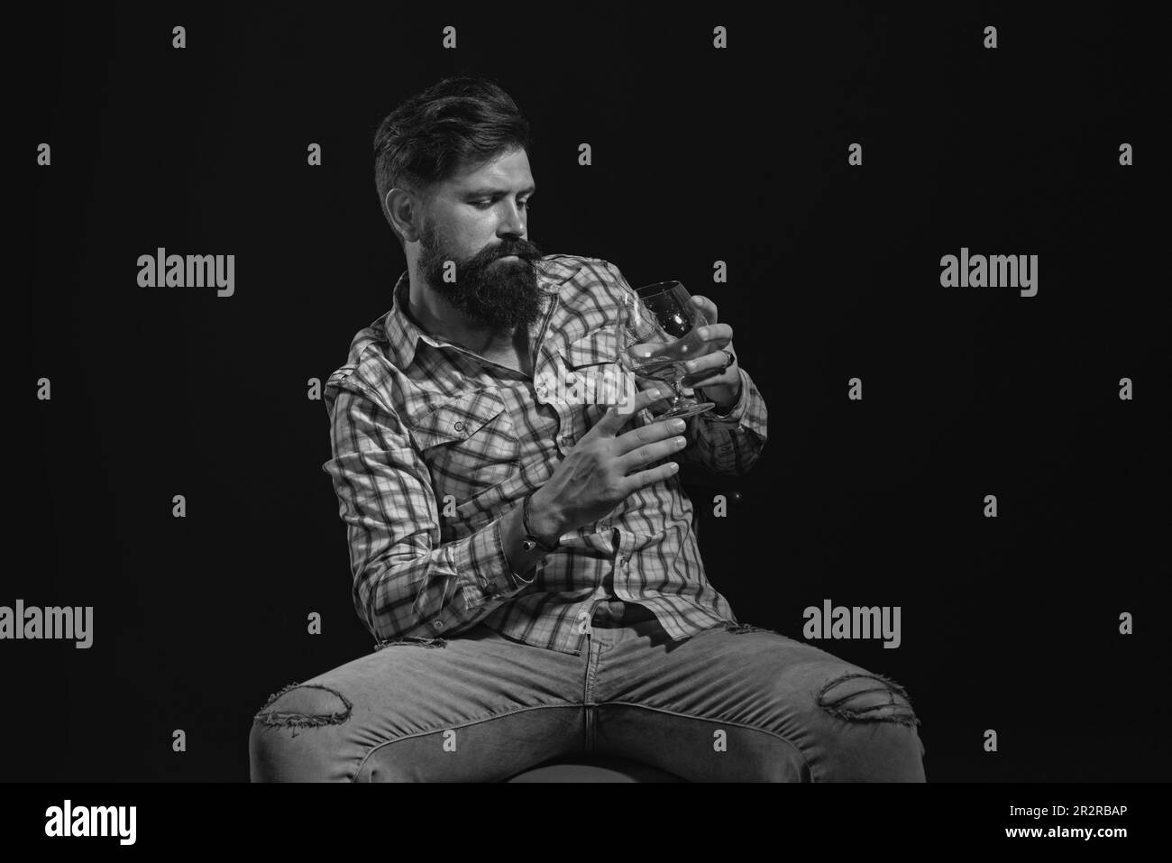 Bearded handsome man holding glass of whiskey. Man with beard holds ...