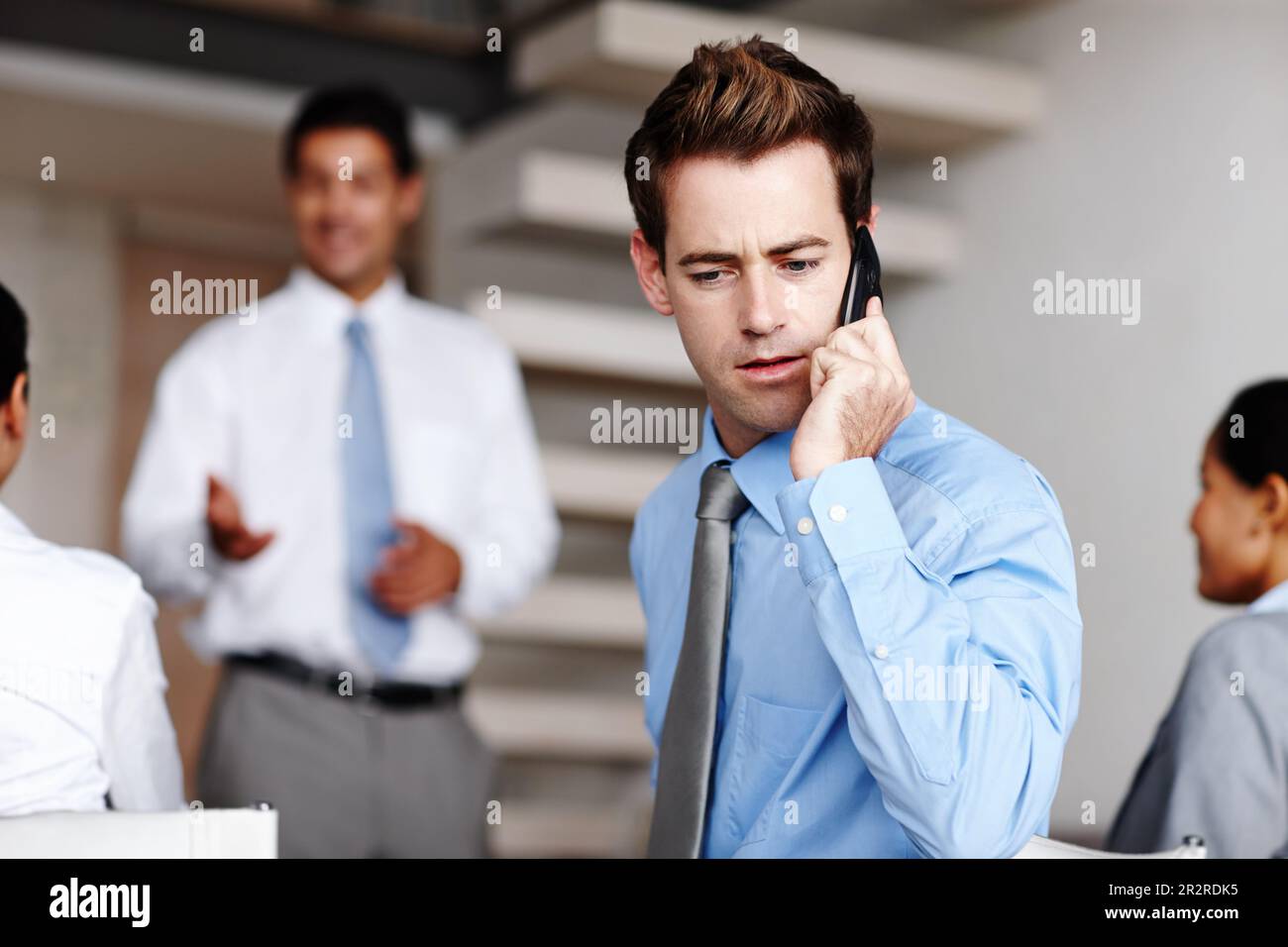 Taking an important call during a presentation. A young executive ...
